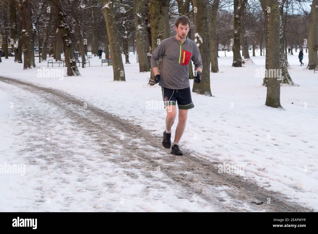 A man running in Edinburgh city center after an early morning snowfall ...