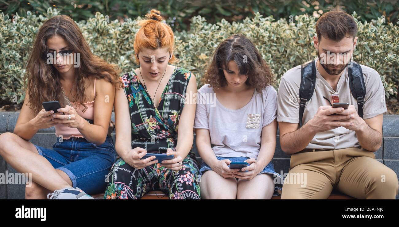 Alienation addiction. Group of friends using smartphones together ...