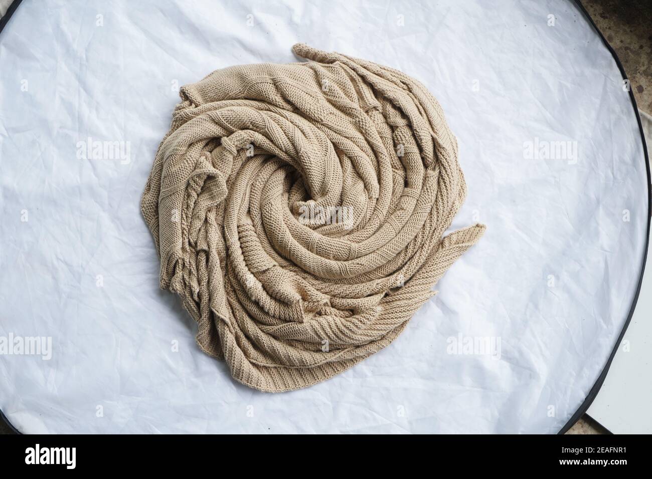 Beige sweater material swirled on a white background Stock Photo - Alamy