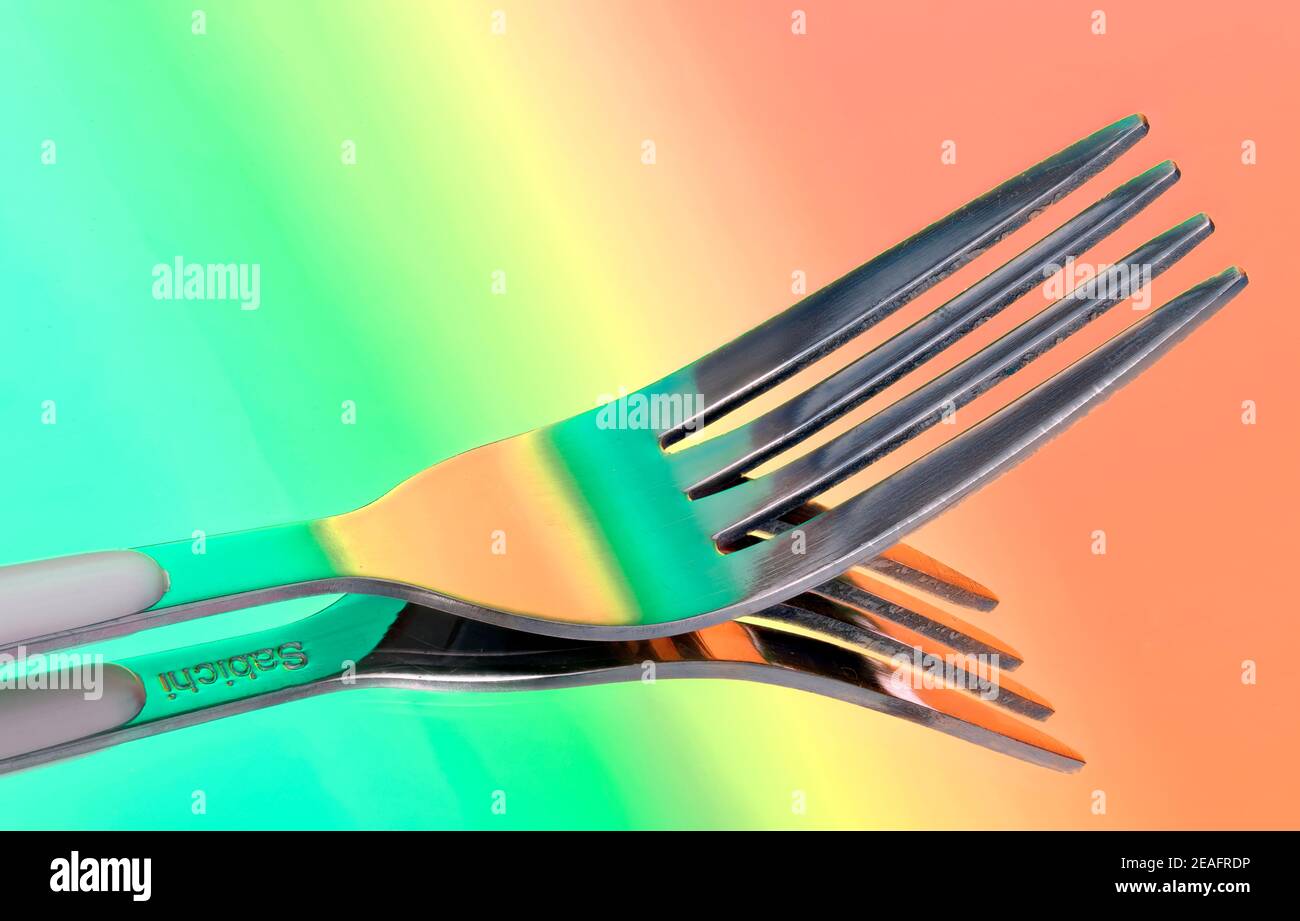 Stainless steel kitchen fork on a reflective surface photographed under ...