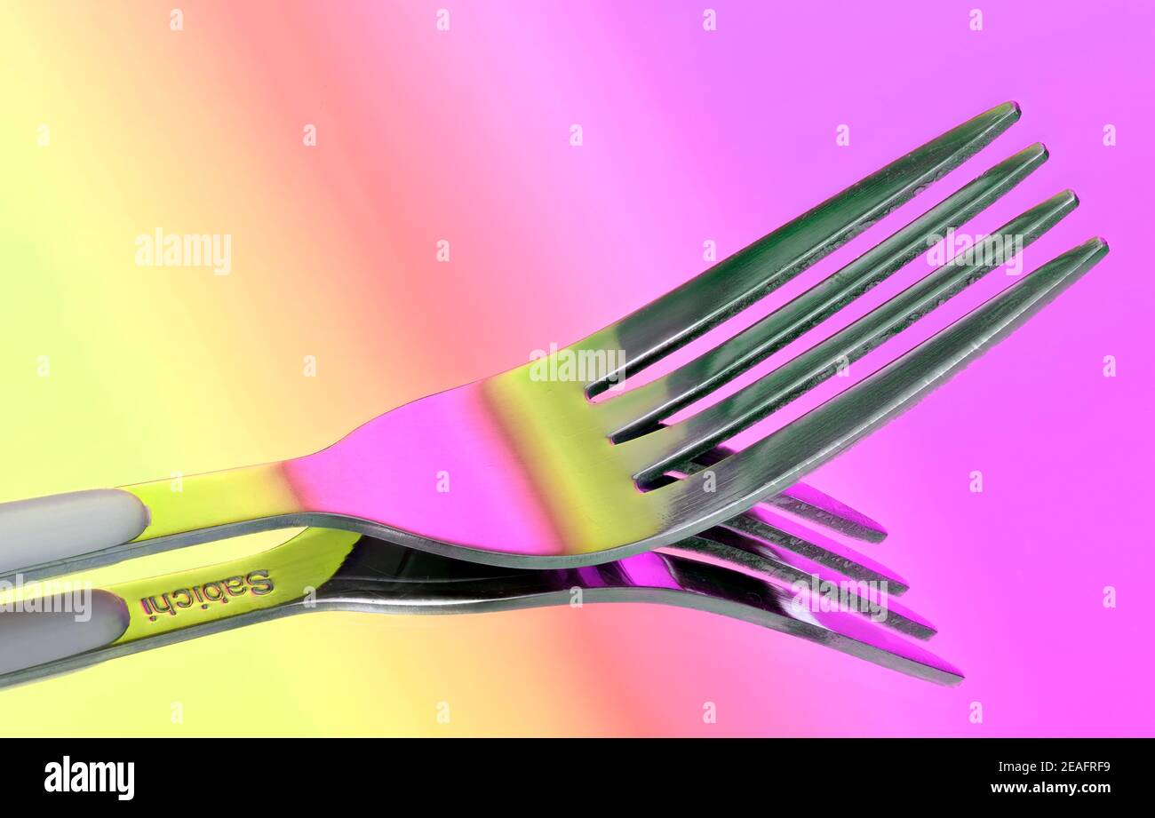 Stainless steel kitchen fork on a reflective surface photographed under ...