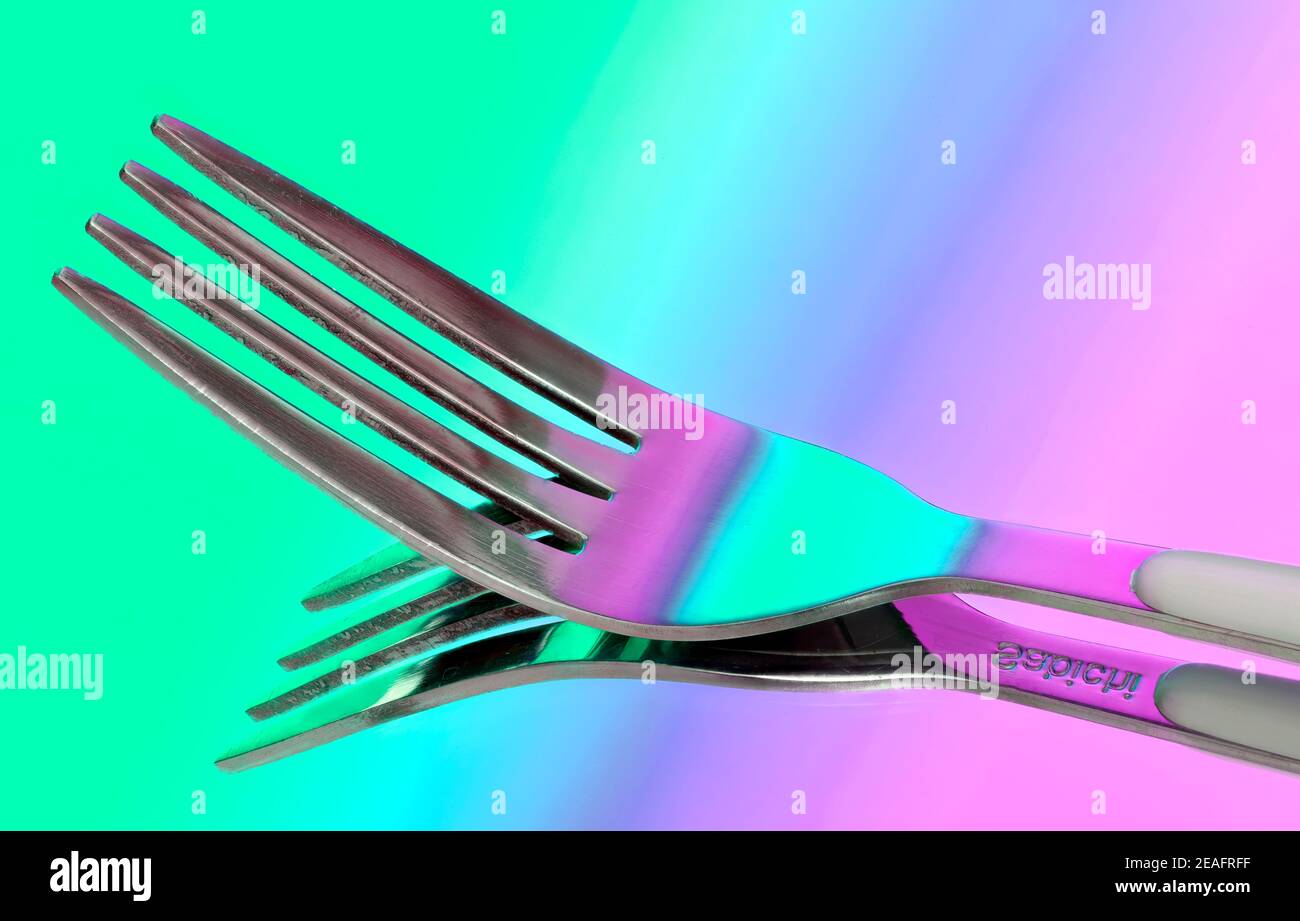 Stainless steel kitchen fork on a reflective surface photographed under ...