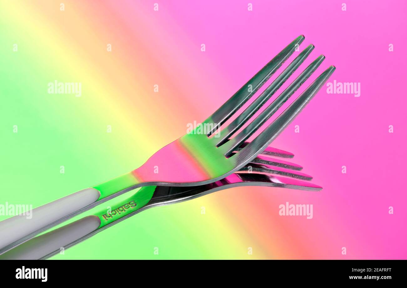 Stainless steel kitchen fork on a reflective surface photographed under ...