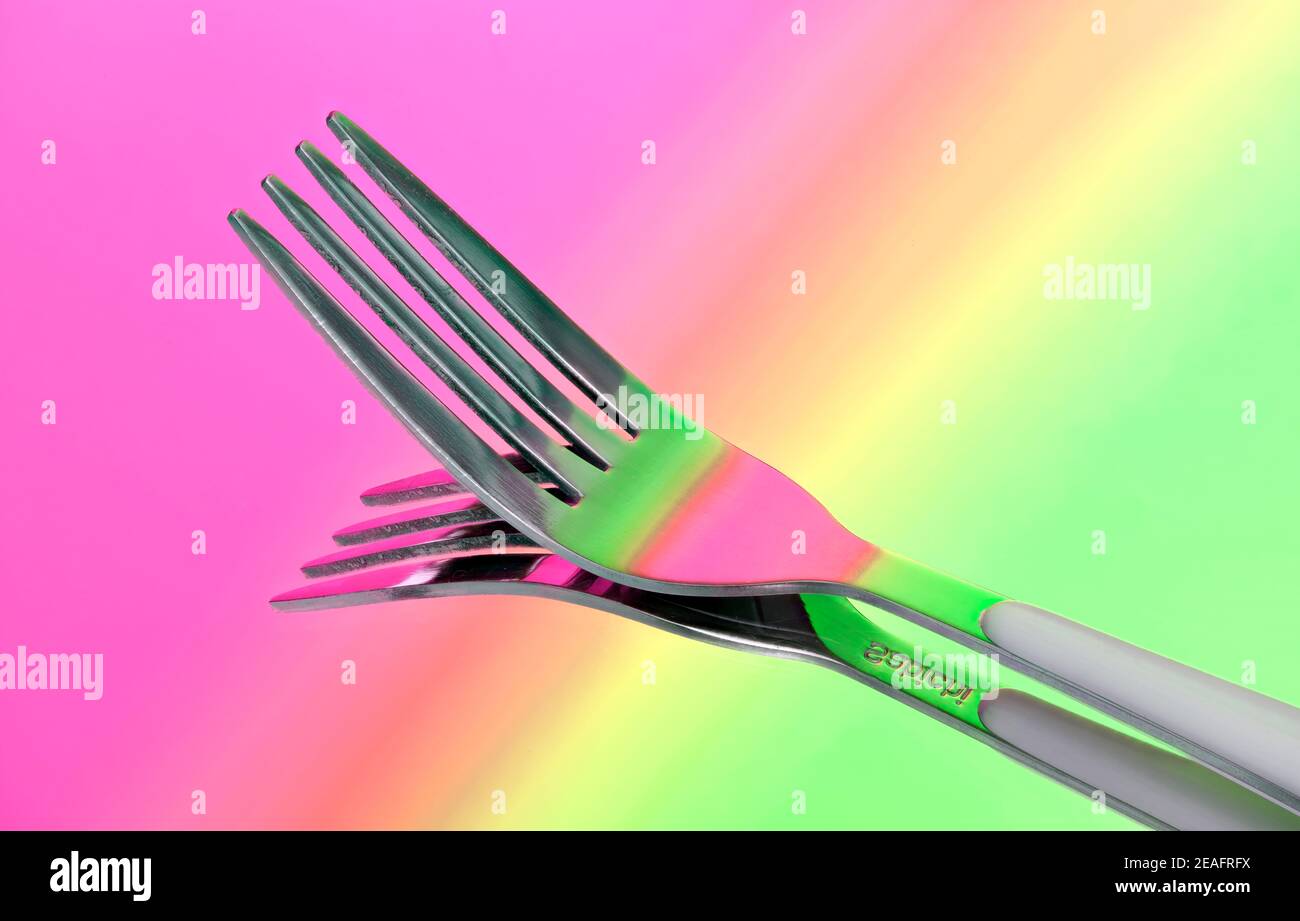 Stainless steel kitchen fork on a reflective surface photographed under ...