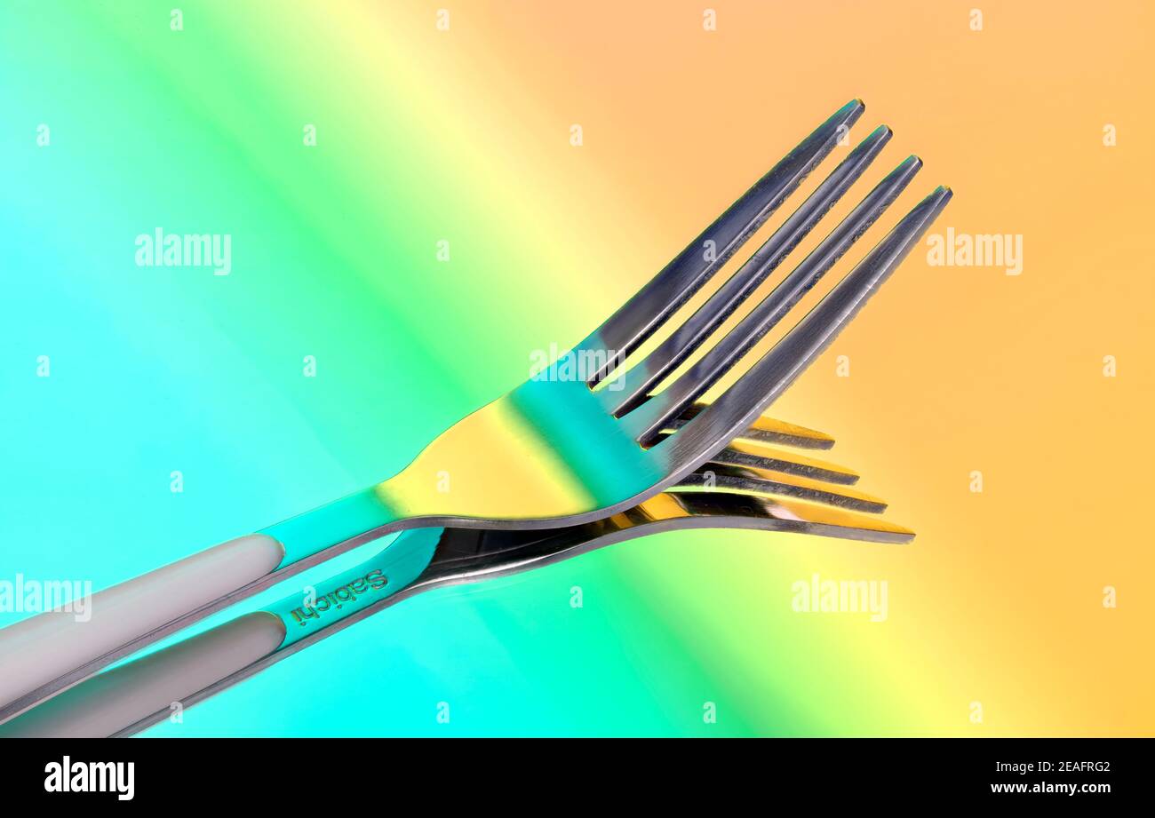 Stainless steel kitchen fork on a reflective surface photographed under ...