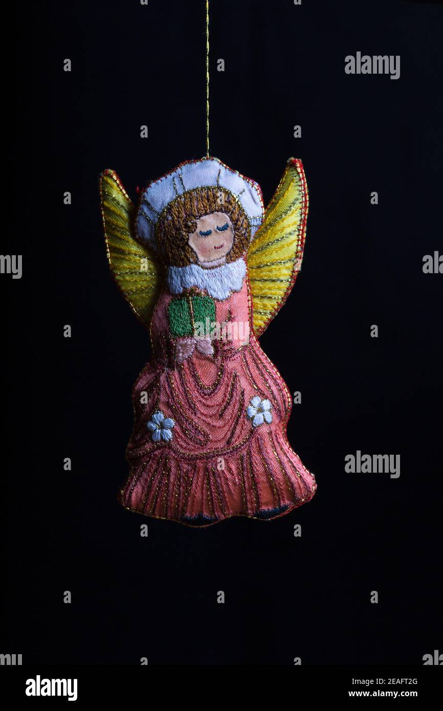 Christmas decorations on string angels with black background Stock ...