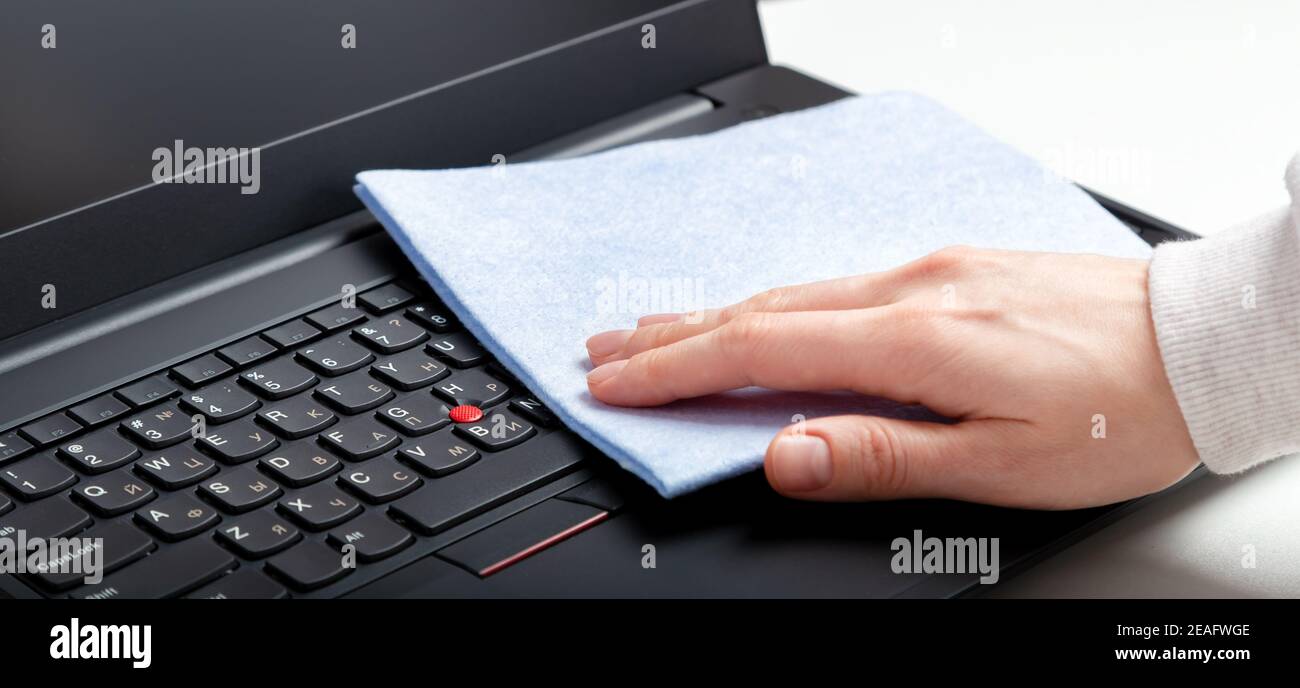 Female hands disinfecting laptop keyboard using wet disinfectant wipes ...