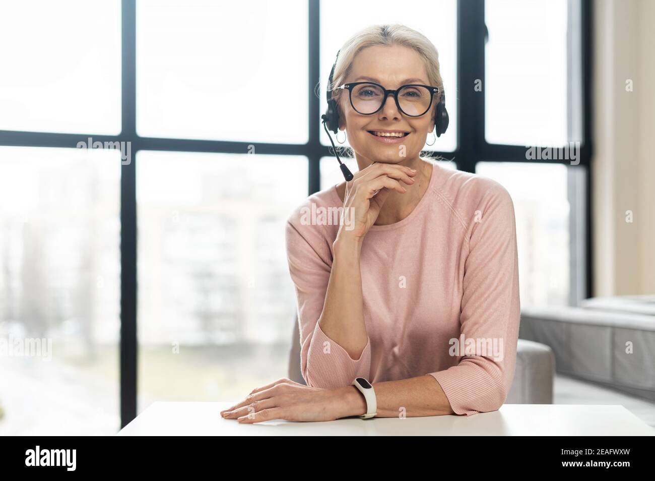 Portrait of a charming smiling elegant mature blonde woman or middle ...