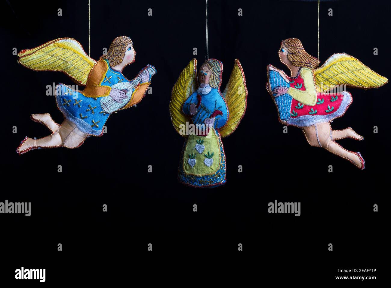 Christmas decorations on string angels with black background Stock ...