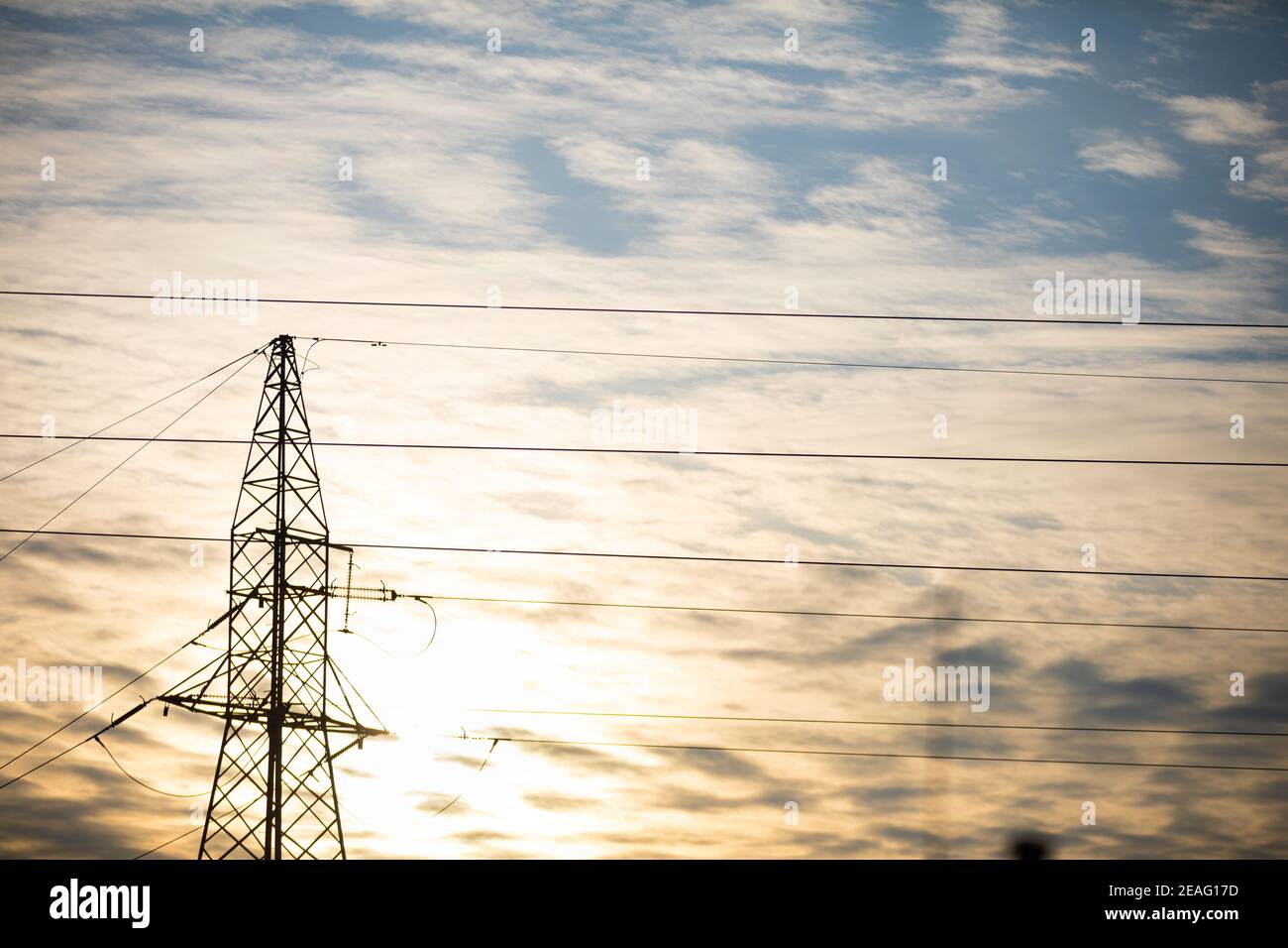 A power pole built on the basis of a truss against the sky and clouds ...