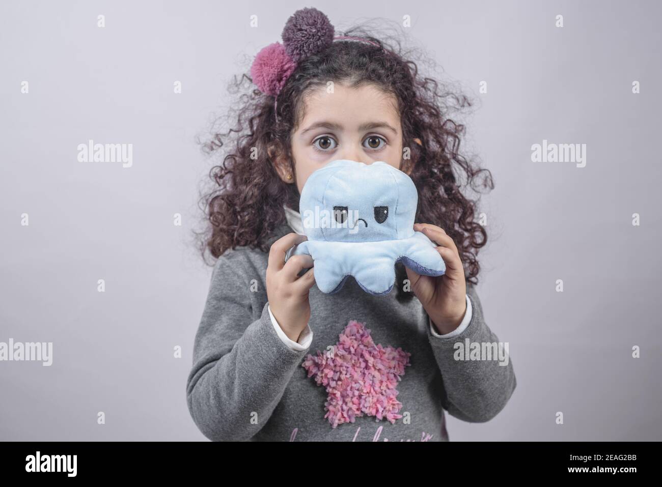 Cute child holding a Sad emotion doll on a grey background Stock Photo ...