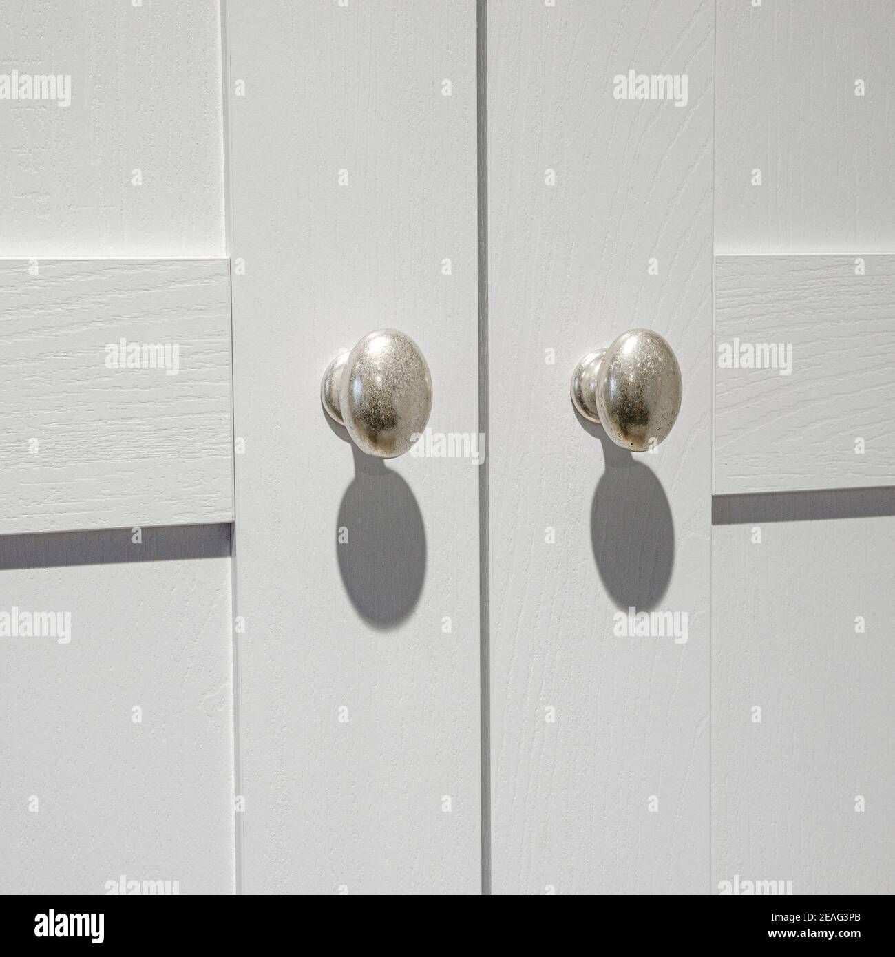 Furniture fittings. Metallic silver door handles with sharp shadows on ...