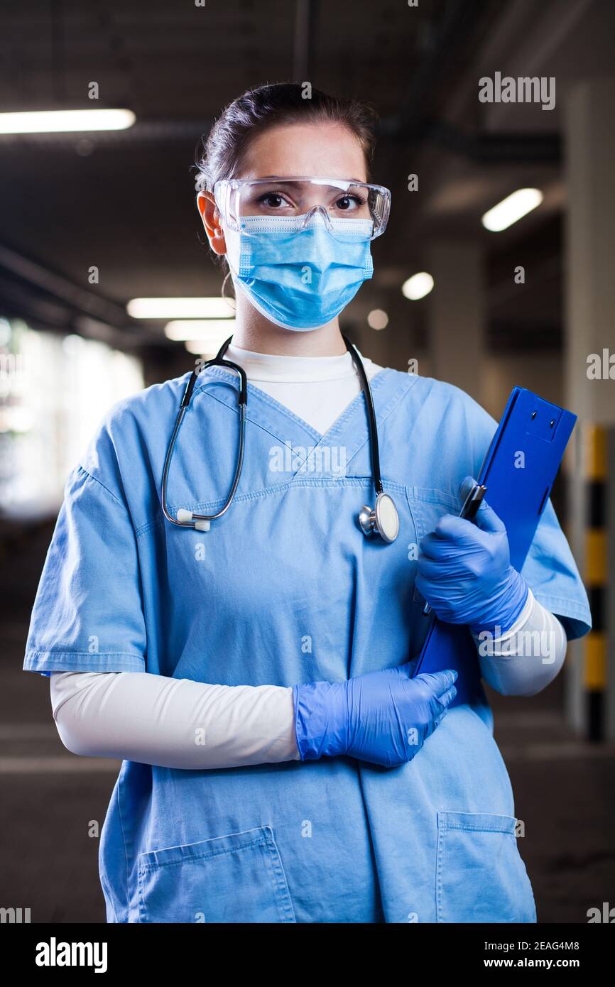 Portrait of young pretty female doctor wearing blue uniform,safety ...
