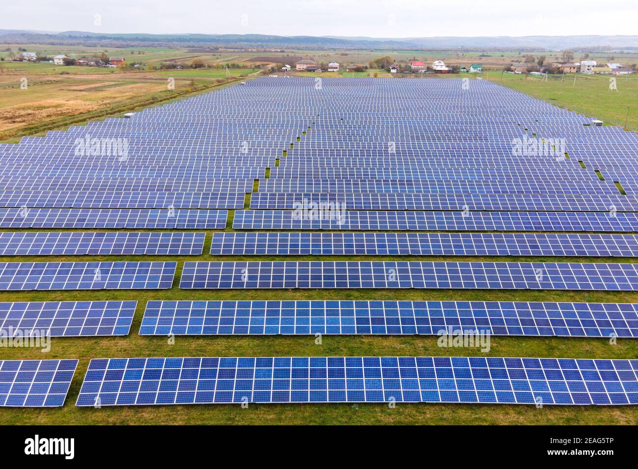Aerial view of solar power plant on green field. Electric farm with panels for producing clean ...