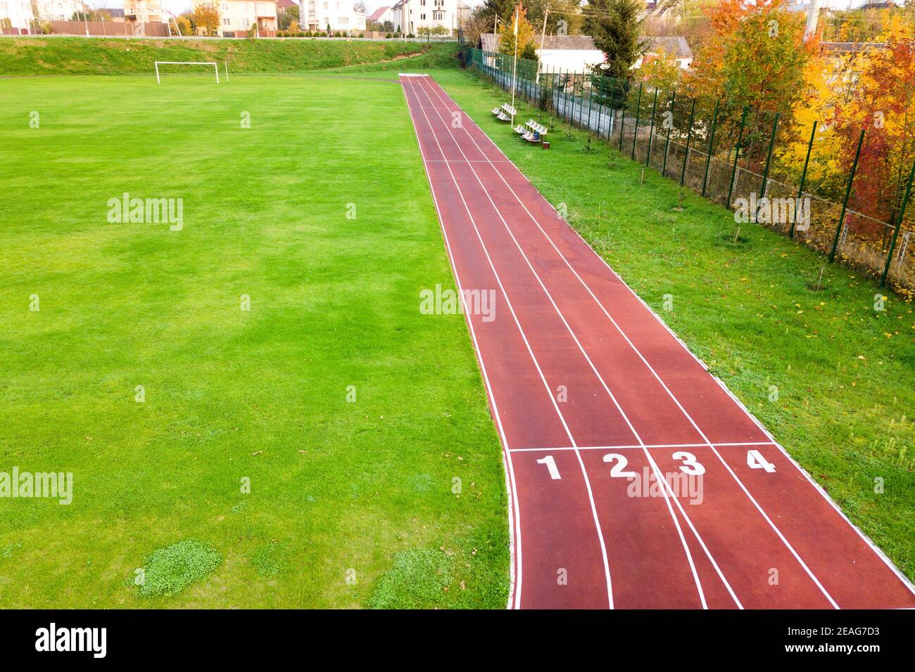 Aerial view of sports stadium with red running tracks with numbers on ...