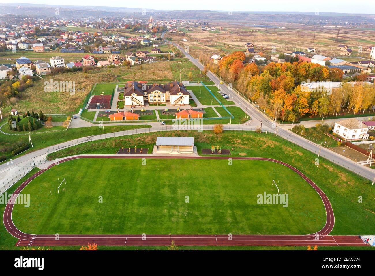 Aerial view of sports stadium with red running tracks and green grass ...