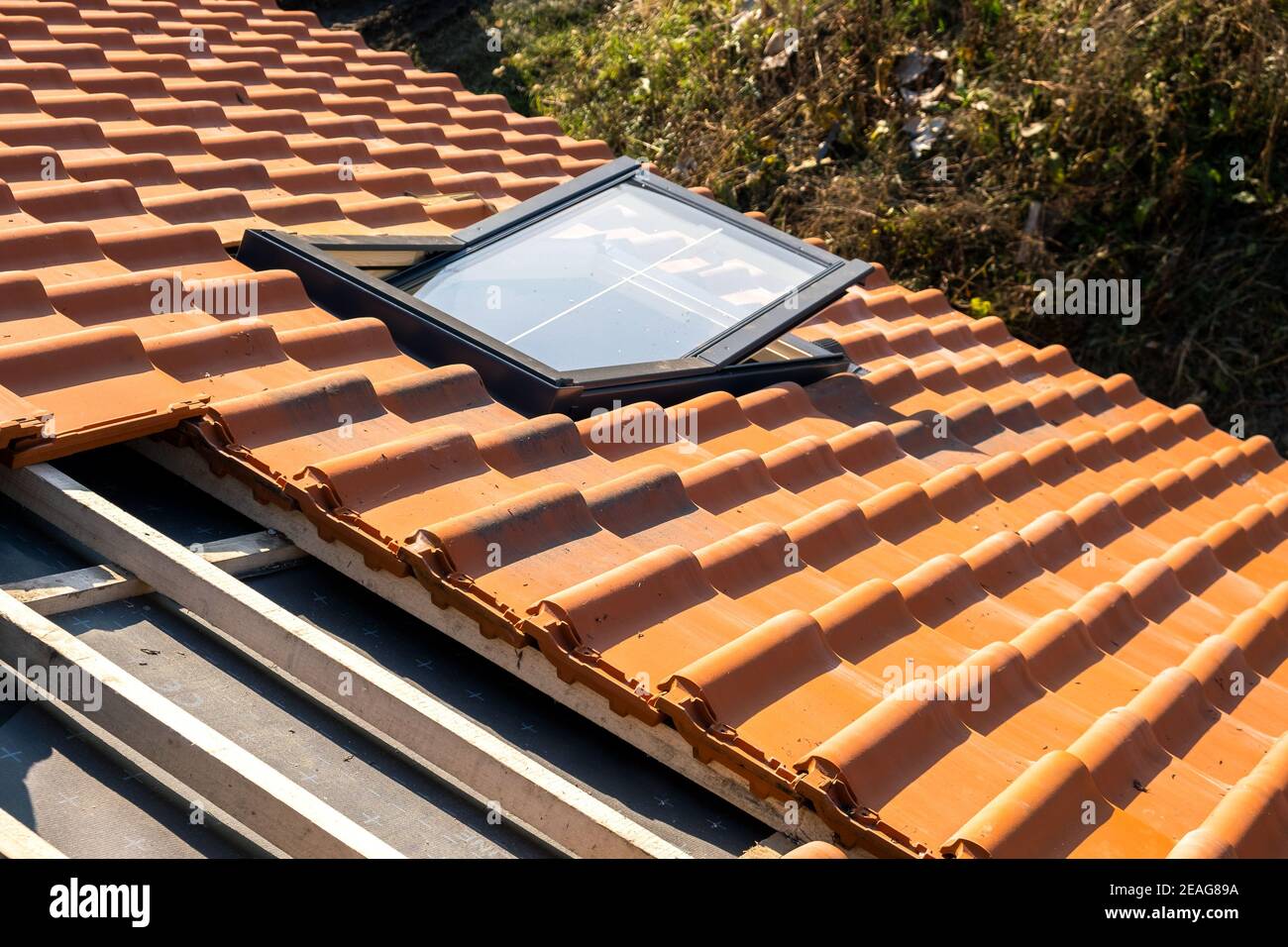 Overlapping rows of yellow ceramic roofing tiles mounted on wooden ...