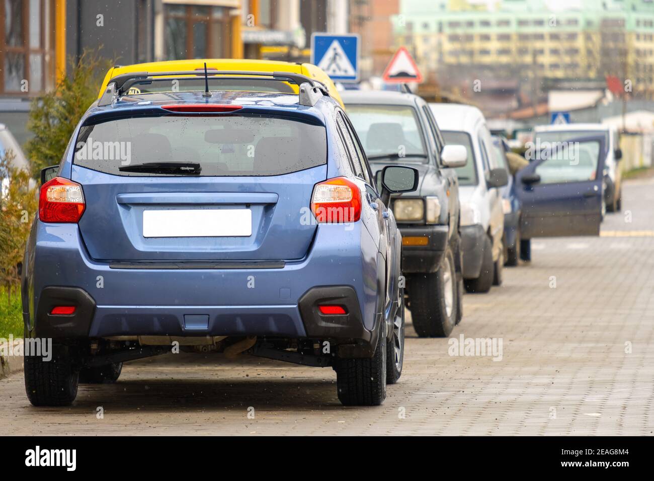 Cars parked in a row on a city street side Stock Photo - Alamy