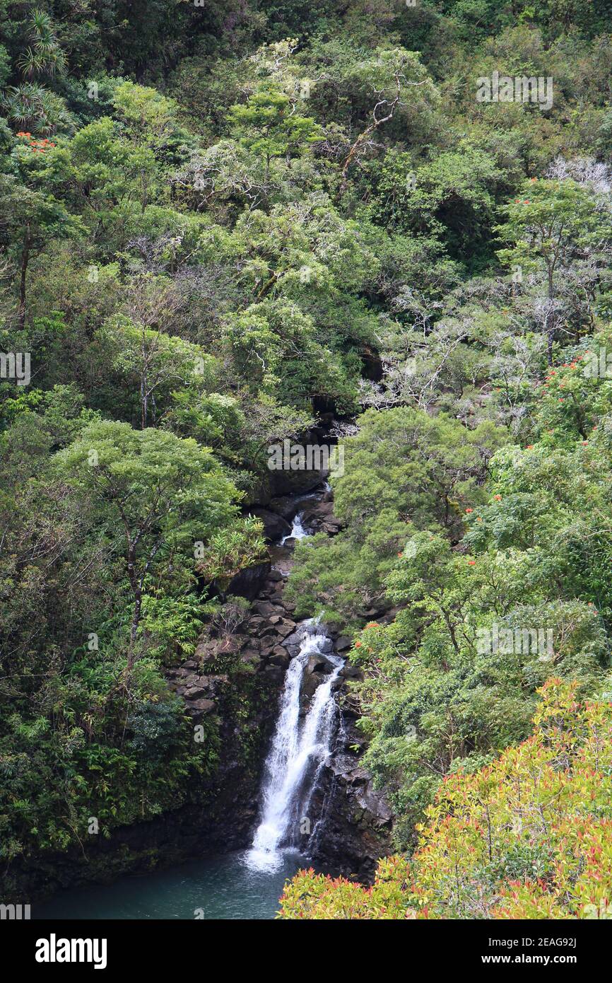 An aerial view of a waterfall and small lake in the middle of a ...