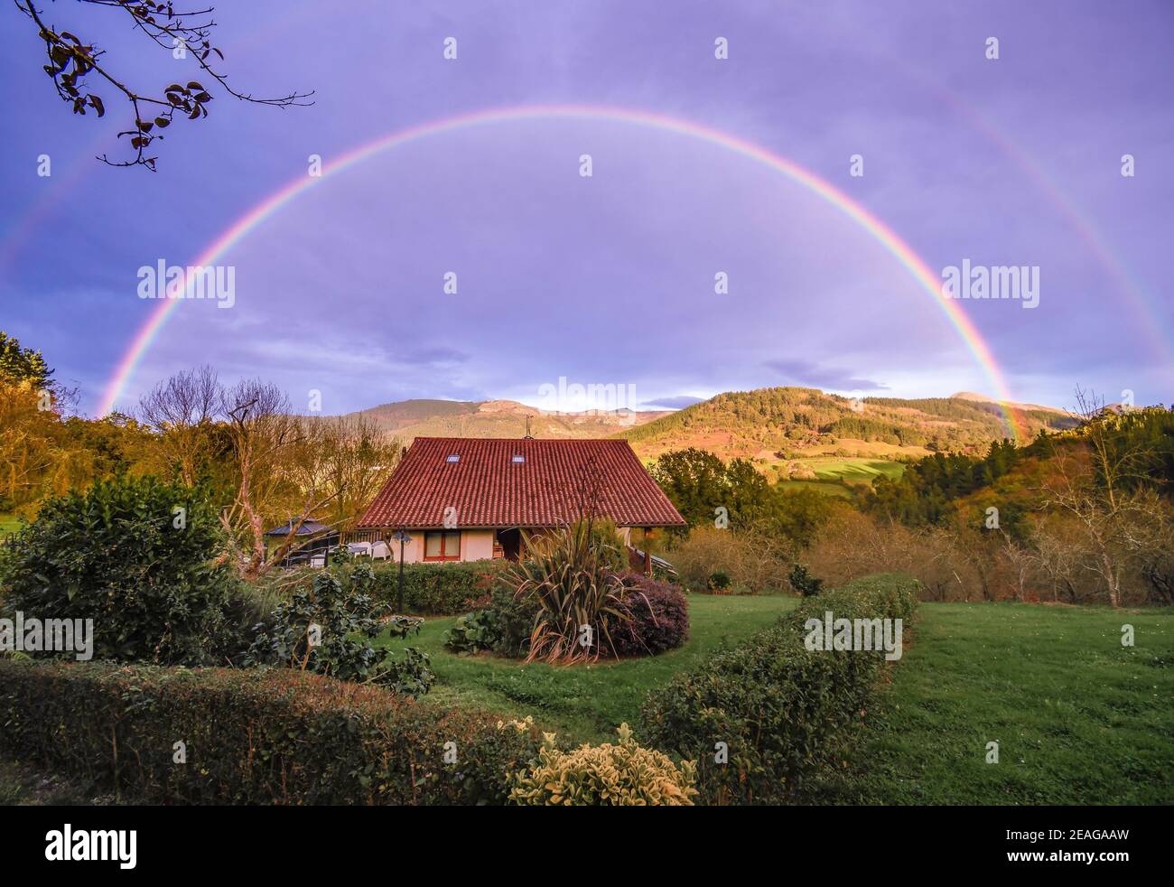 Double and complete rainbow over country house with the Triano ...