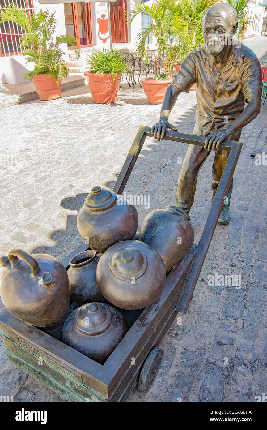 A statue of a man pushing a cart of clay pots / tinajónes in Camagüey ...