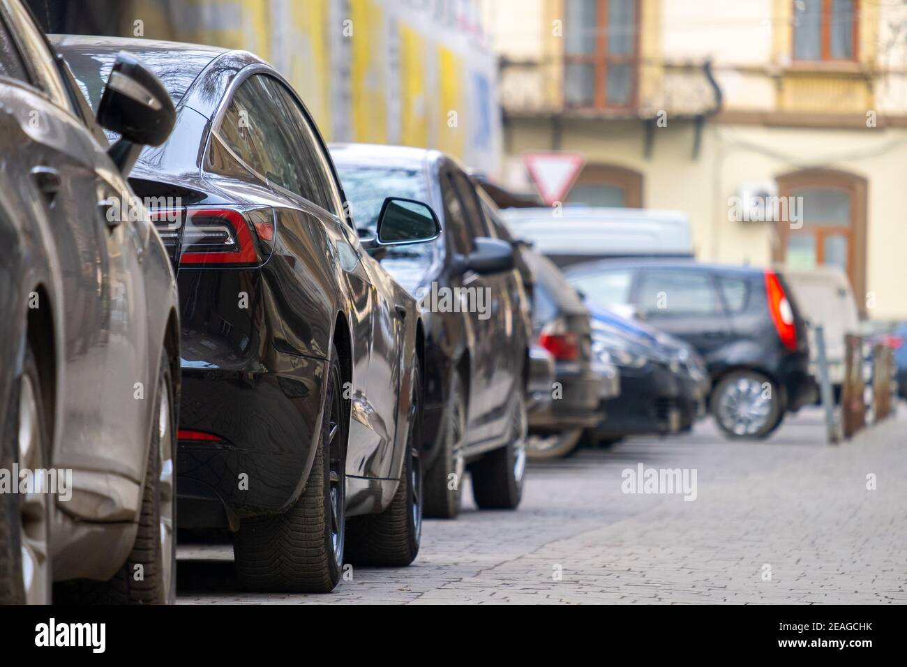 Cars parked in a row on a city street side Stock Photo - Alamy