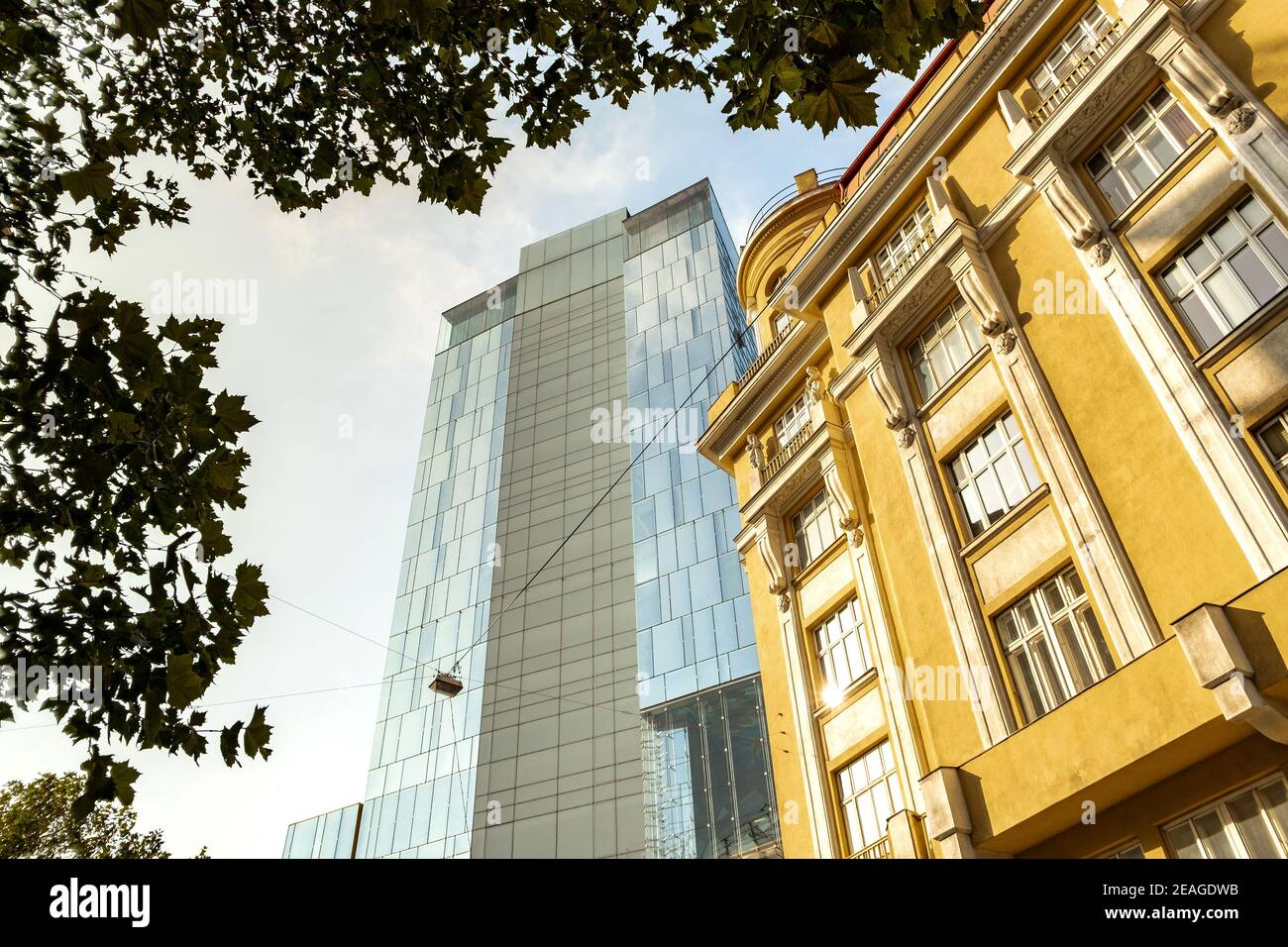Perspective view of modern high-rise glass skyscraper and old buildings ...