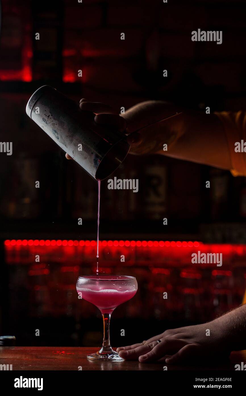 Classic Pink Lady cocktail closeup with flower and cherry on bar ...