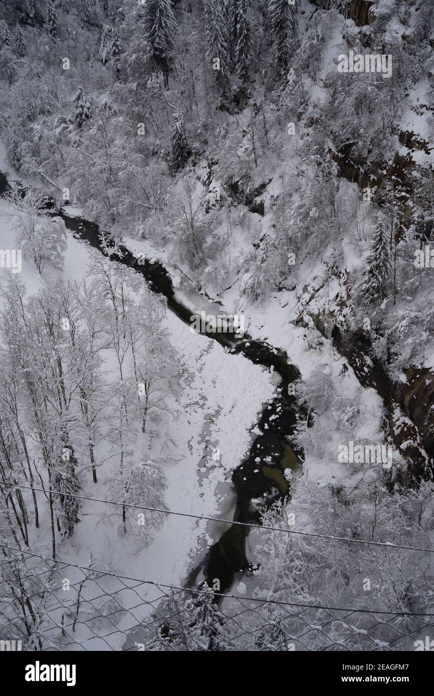 Snow covered landscape with a river and a forest after a heavy snowfall ...
