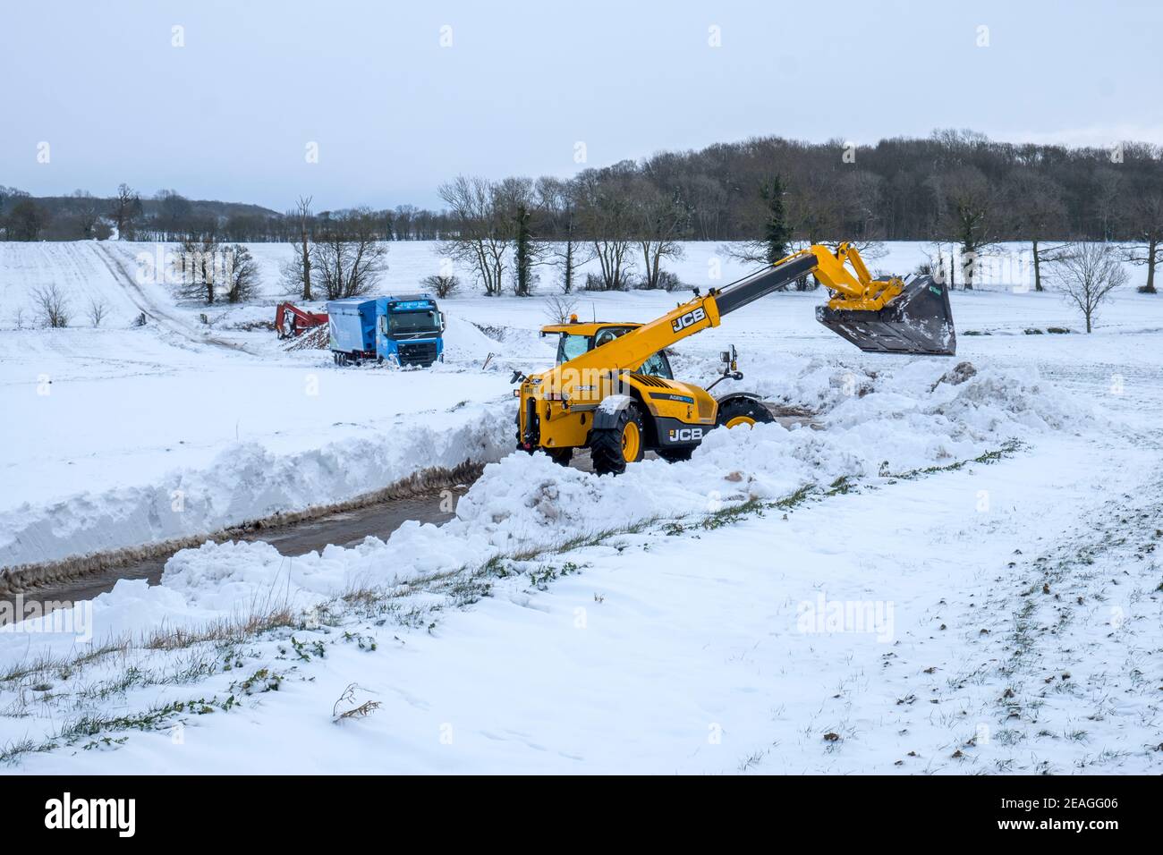 An excavator clears the snow for a lorry that has been stuck in the ...