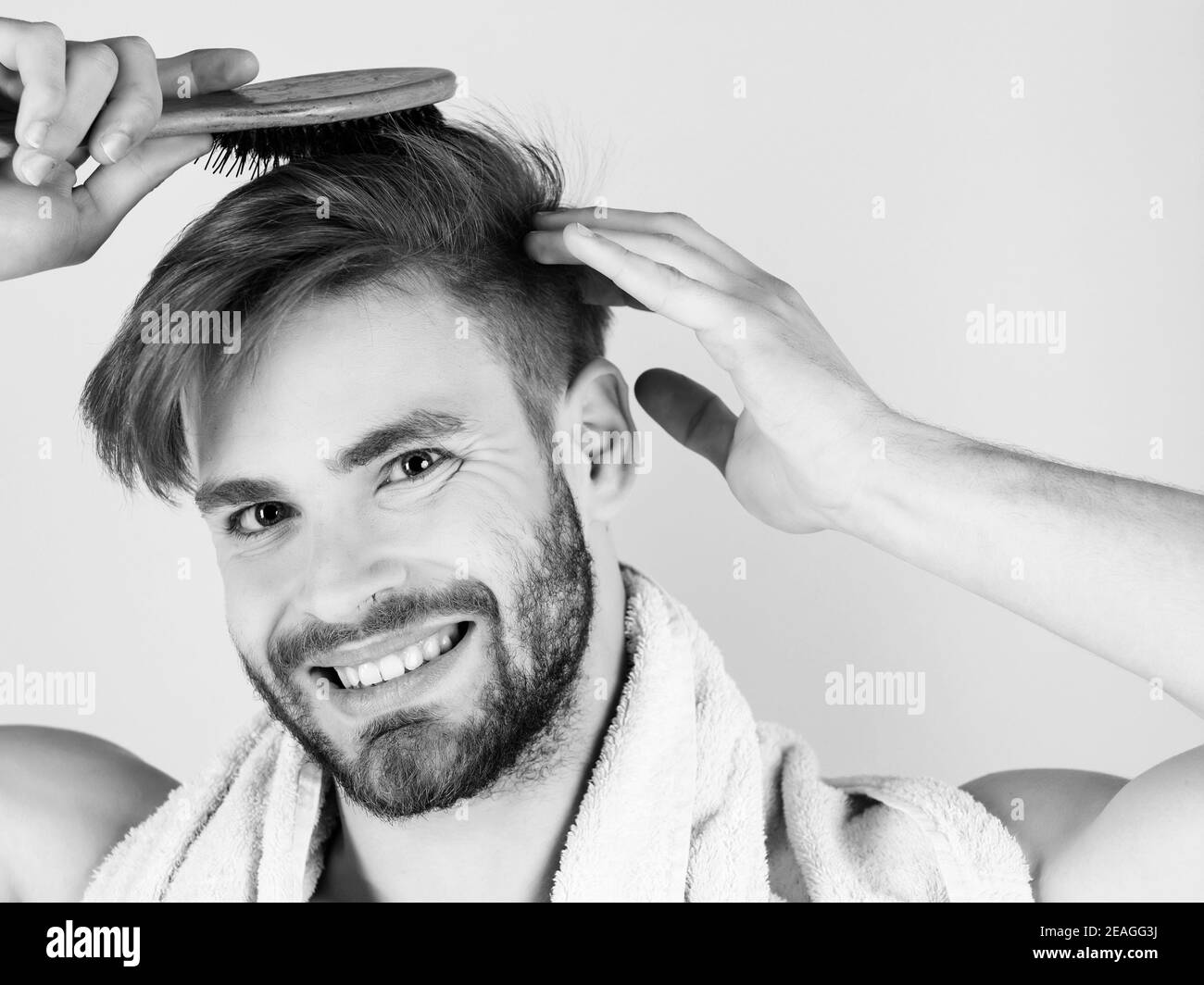 Man combing healthy hair with brush in strong arms. Male grooming and ...