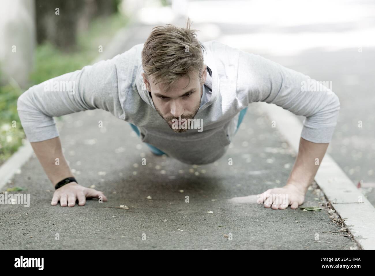 Strength and motivation. Man in sportswear doing push ups outdoor. Guy ...