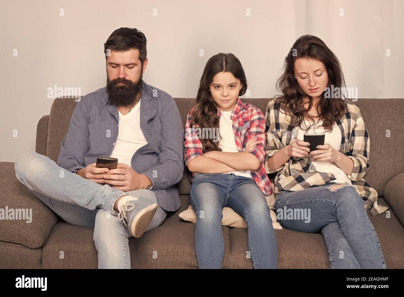 Technology distracting family from child. Small child and parents ...