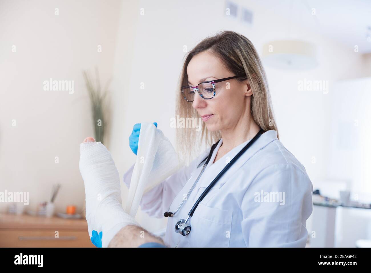 Professional nurse bandaging the patient's leg with a medical bandage ...