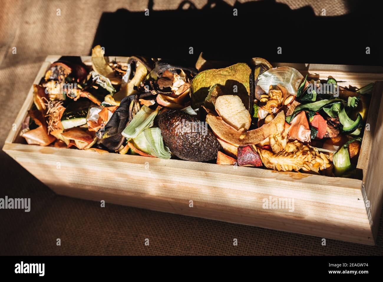 Peelings and organic waste in a wooden crate to create homemade compost ...