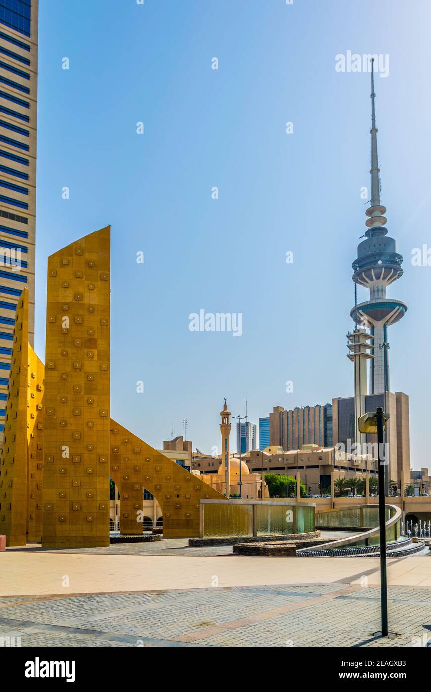 View of a a golden monument with a small park in the central Kuwait ...