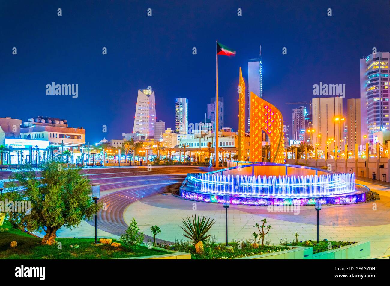 View of a a golden monument with a small park in the central Kuwait ...