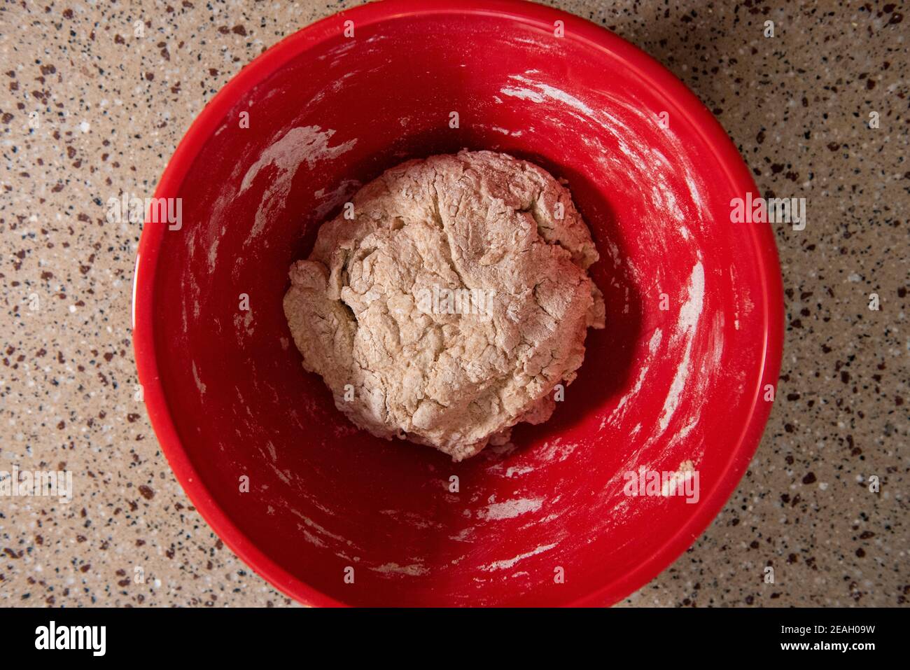 A ball of bread dough in a red mixing bowl. Series step-by-step making ...