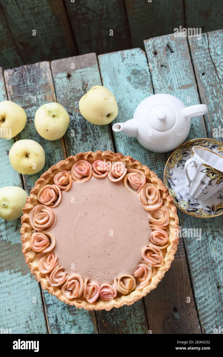 Apple rose pie with cream filling served with organic apples and tea on ...