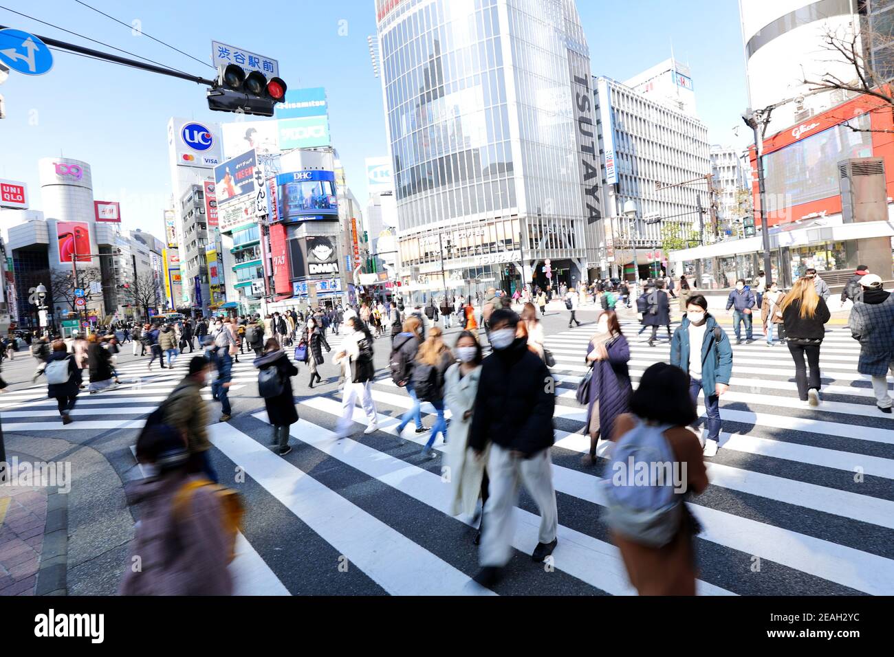 People wearing face masks walk at Shibuya shopping district in Tokyo ...
