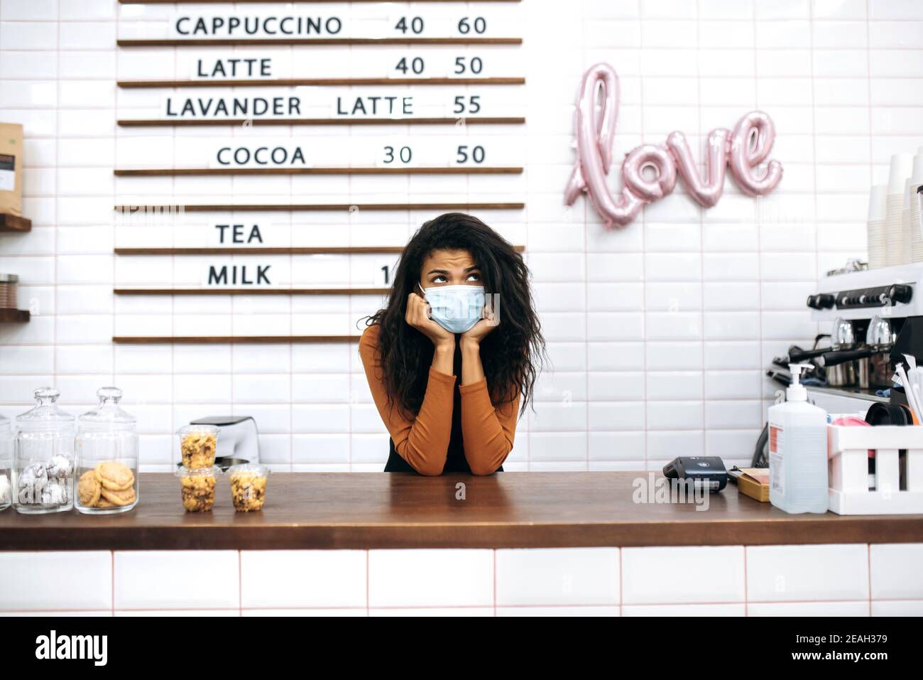 Sad young African American female barista wearing uniform and ...