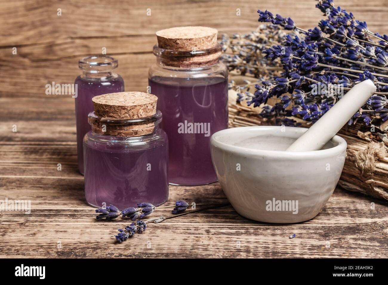 Dried lavender flowers in a in a mortar and pestle with bottle of essential lavender oil or ...