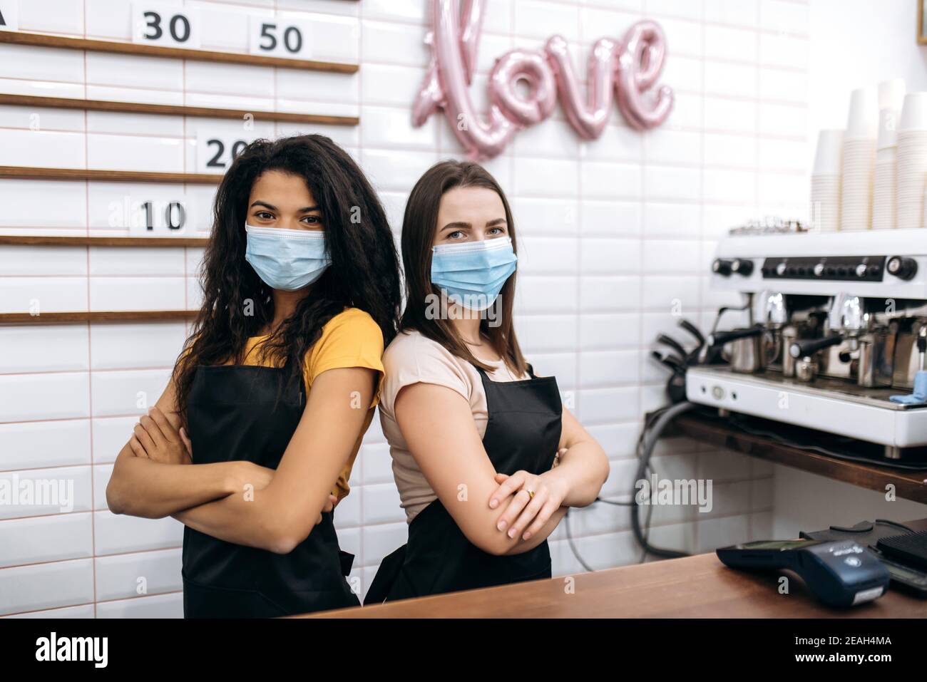 Portrait of two female waitress a coffee shop, African American and ...