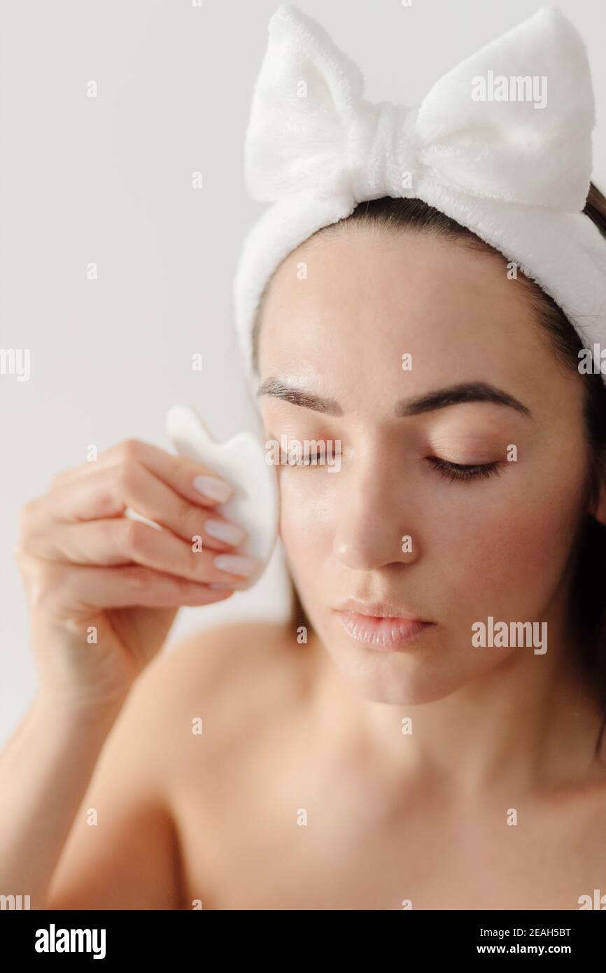 Woman using Gua Sha scraper over skin Stock Photo - Alamy