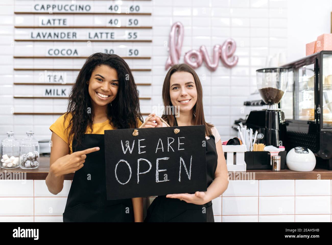 Two satisfied African American and caucasian female waitress a coffee ...