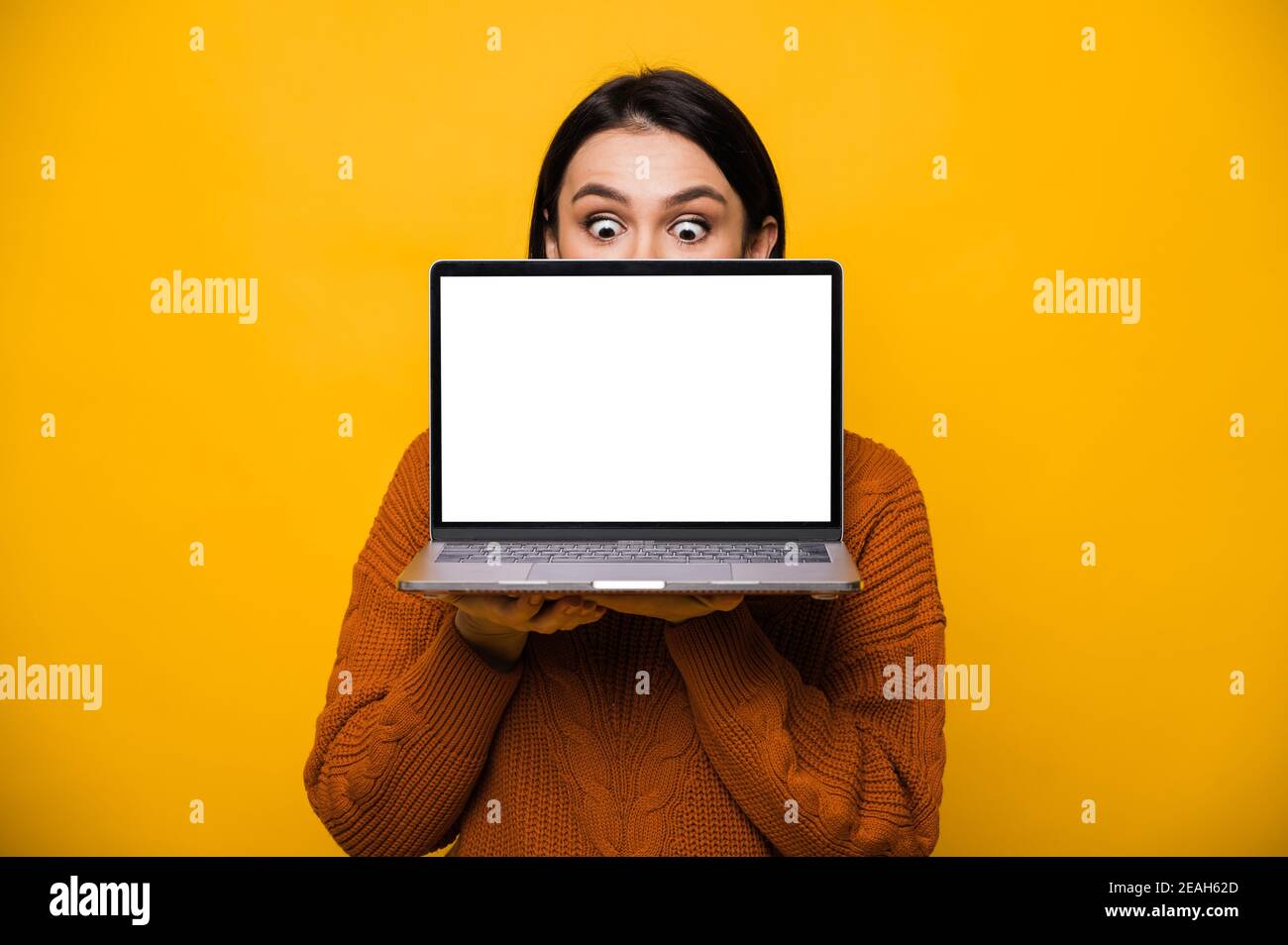 Portrait of a surprised shocked caucasian young woman, hiding behind ...