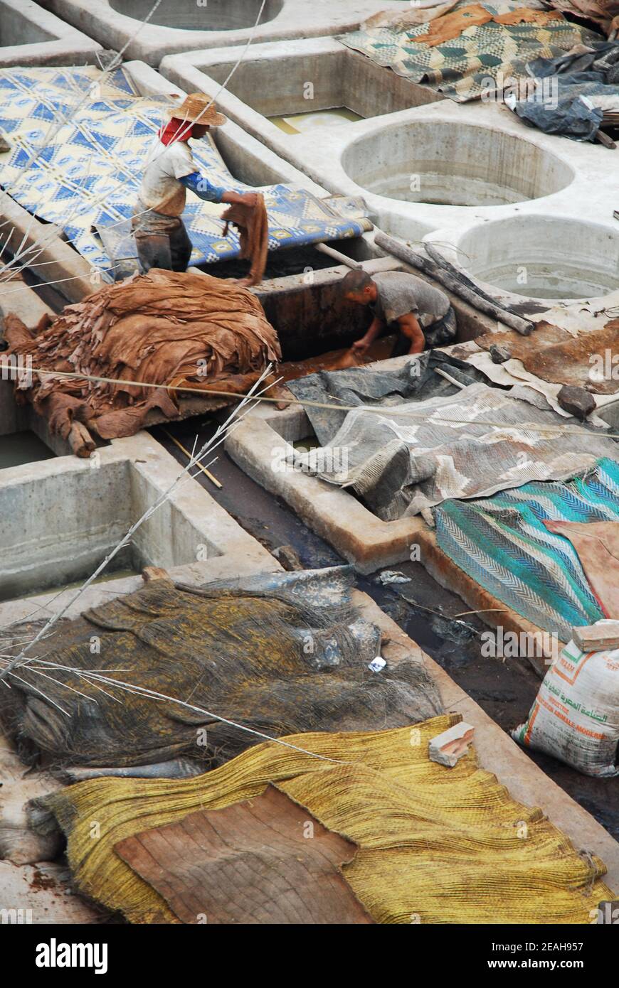 Two men working in leather tanning pits in Morocco Stock Photo - Alamy