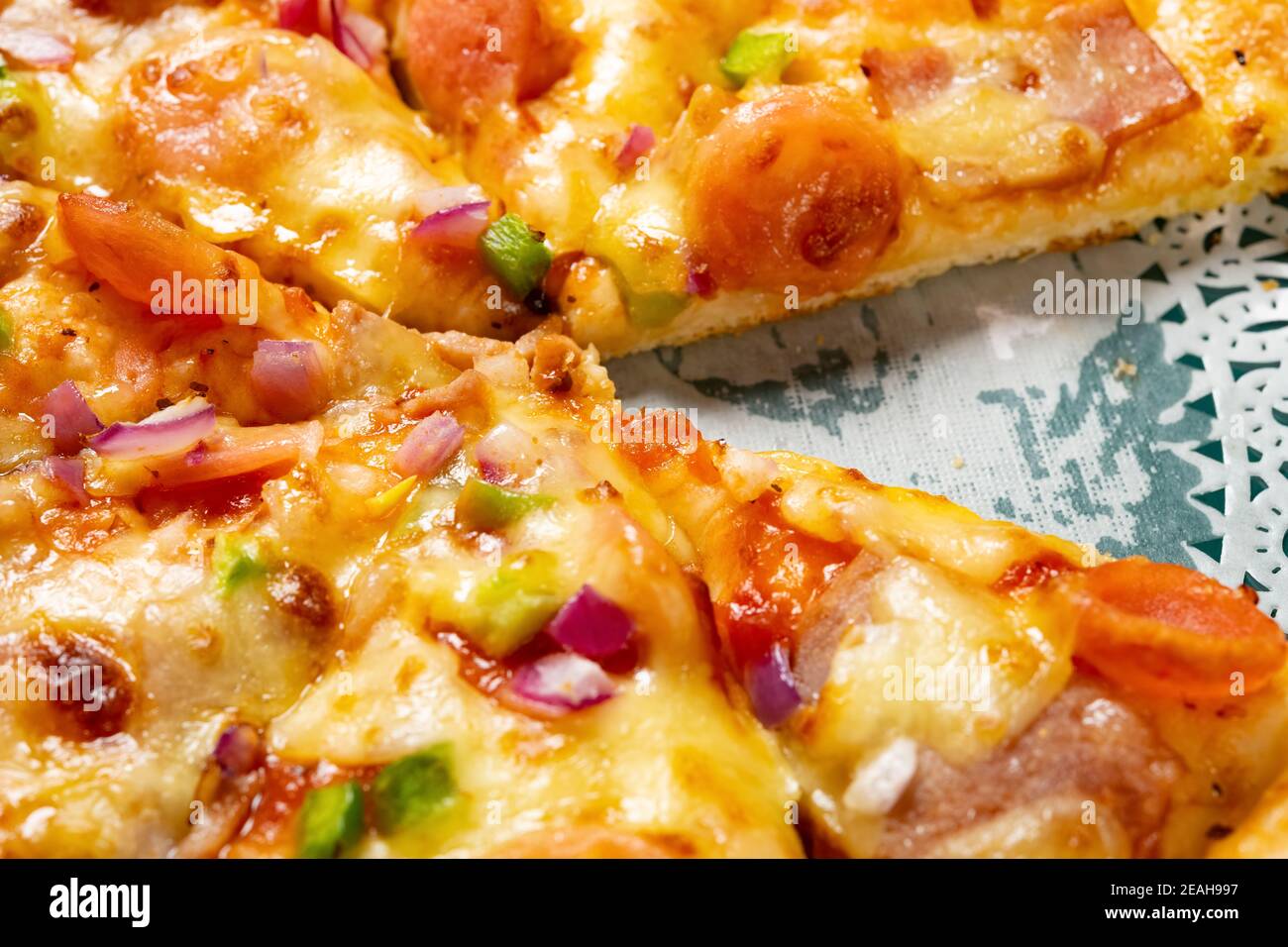 side view fresh pizza with bacon toppings with one piece missed close ...