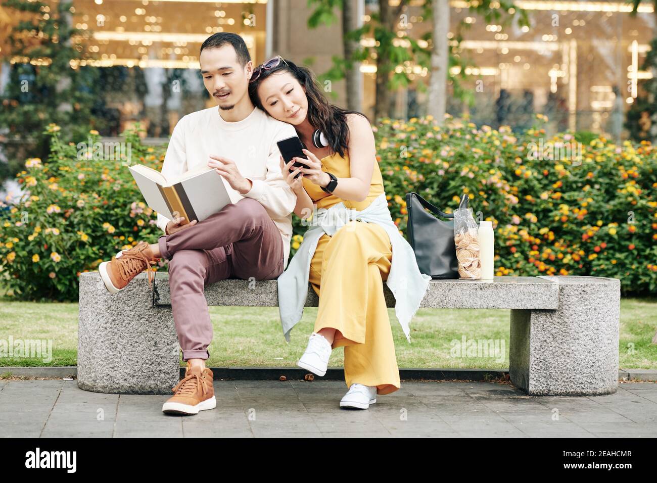 Couple resting on bench Stock Photo - Alamy