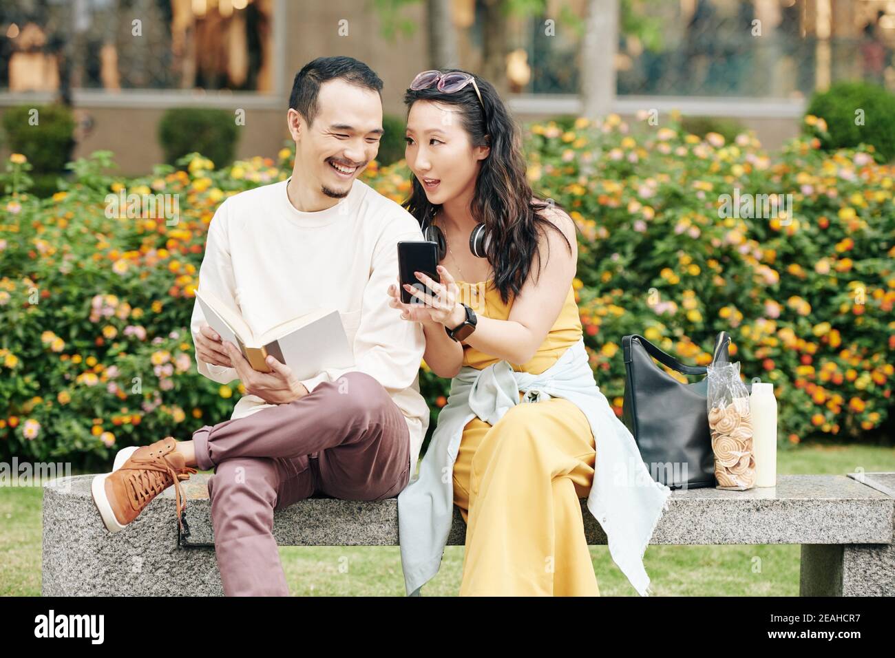Couple resting on bench Stock Photo - Alamy
